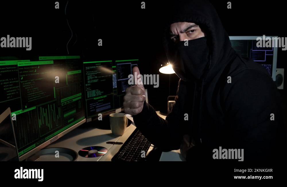 Cyber hacker with hood and covered face showing thumb up with hand ...