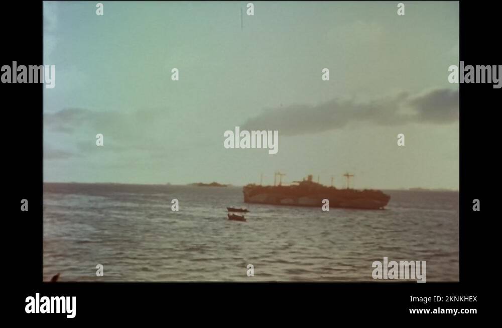 1940s: Naval ship and support craft in the Pacific Ocean at dawn. Naval ...