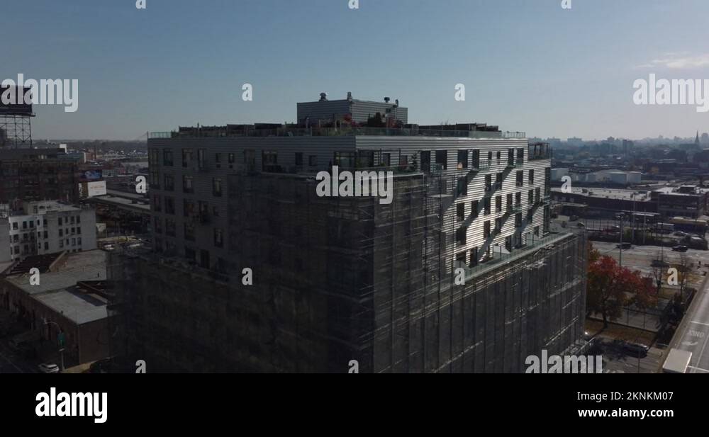 Fly over apartment building with rooftop terraces and scaffolding ...