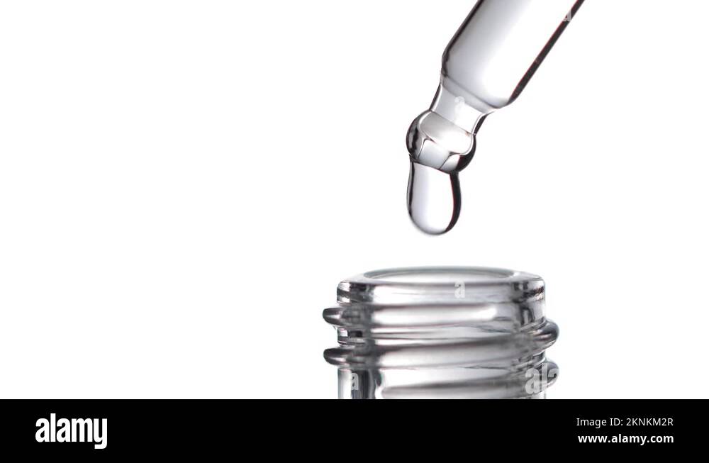 Drop of water falling from glass lab pipette in bottle on white ...