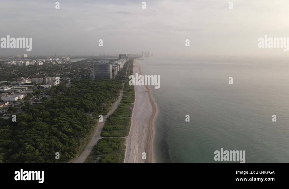 Misty fog sunrise aerial over empty Surfside sand beach, Miami Florida ...