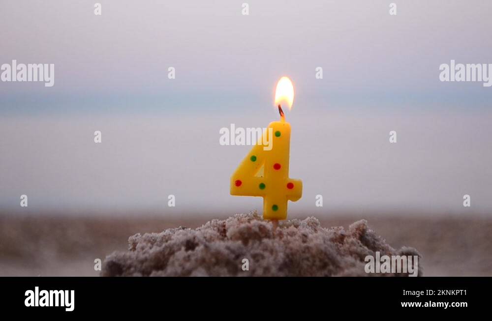 Candle number four inserted sand and burns. Lighted candle in sand on ...
