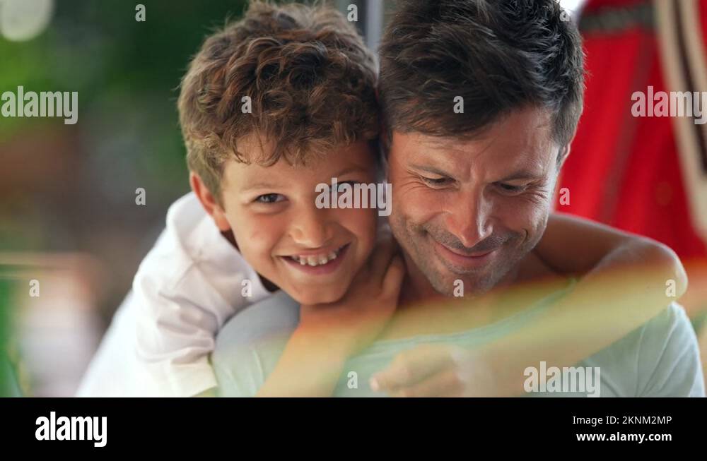 Child kissing father on the cheek, candid and real life family love and ...