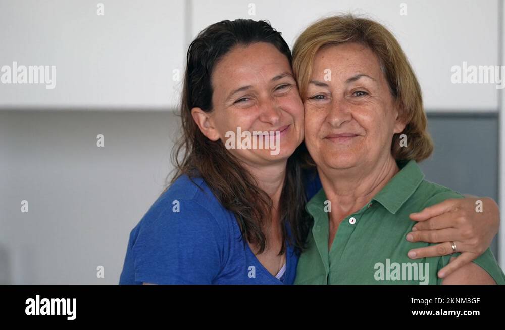 Older mother and adult daughter embracing looking at camera, family of ...