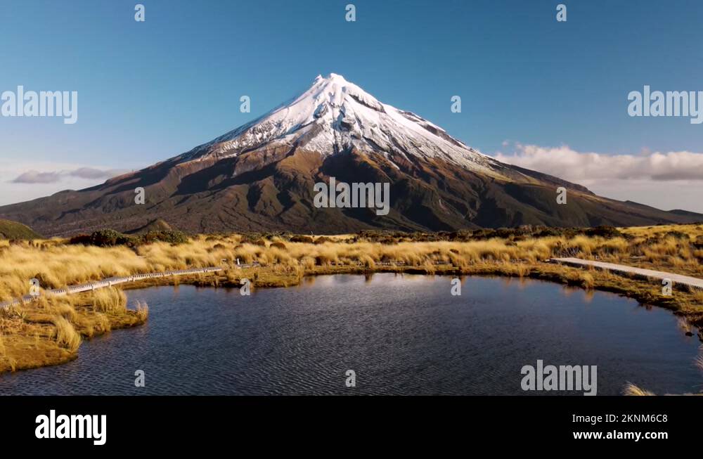 Amazing view of iconic Taranaki volcano aerial reveal of couple tourist ...