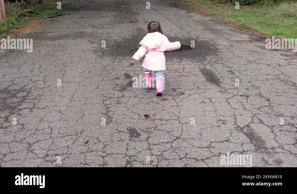 Chasing after a cute little girl as you splashes in a tiny puddle Stock ...
