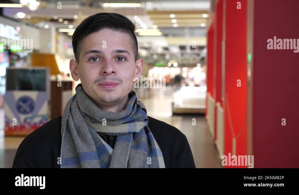 Portrait of a young european guy in a shopping mall in winter, close-up ...