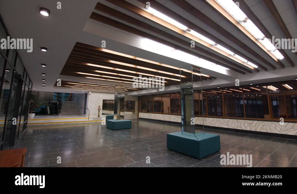 Mirrored columns with poufs in empty hall of shopping center Stock ...