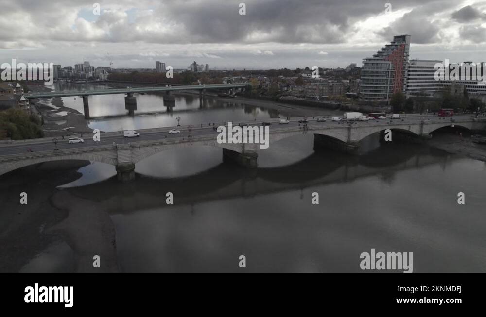 Queue of slowly moving vehicles passing on bridge over water Stock ...