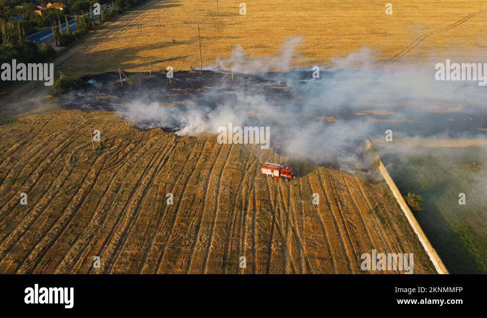 Cinematic footage fire truck in clouds of smoke at hearth of dry ...