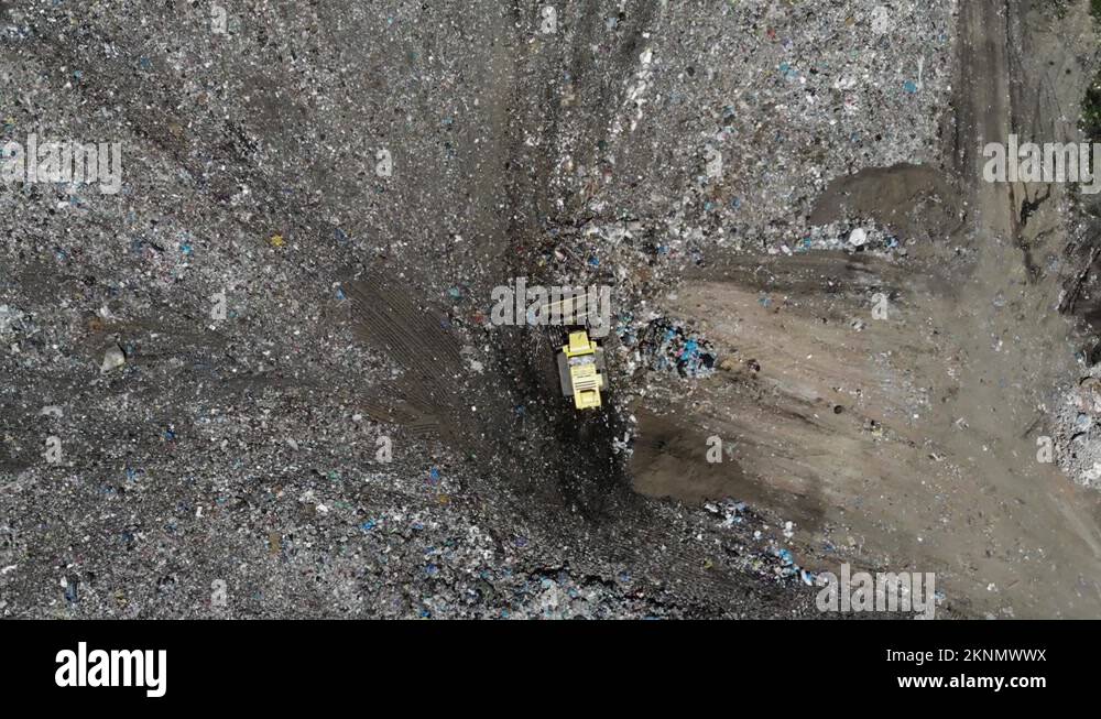 Bulldozer pushing waste in a garbage huge landfill - aerial view Stock ...