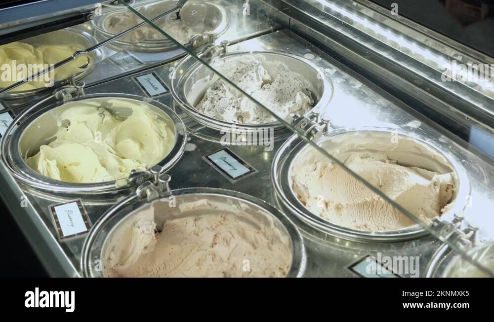 Variety of ice cream gelato range on the cafeteria shelf, pastel colors ...