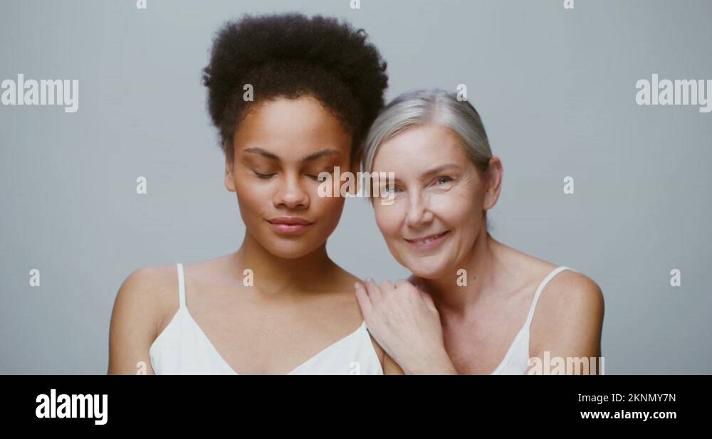 An elderly and a young models pose together smiling looking at the ...