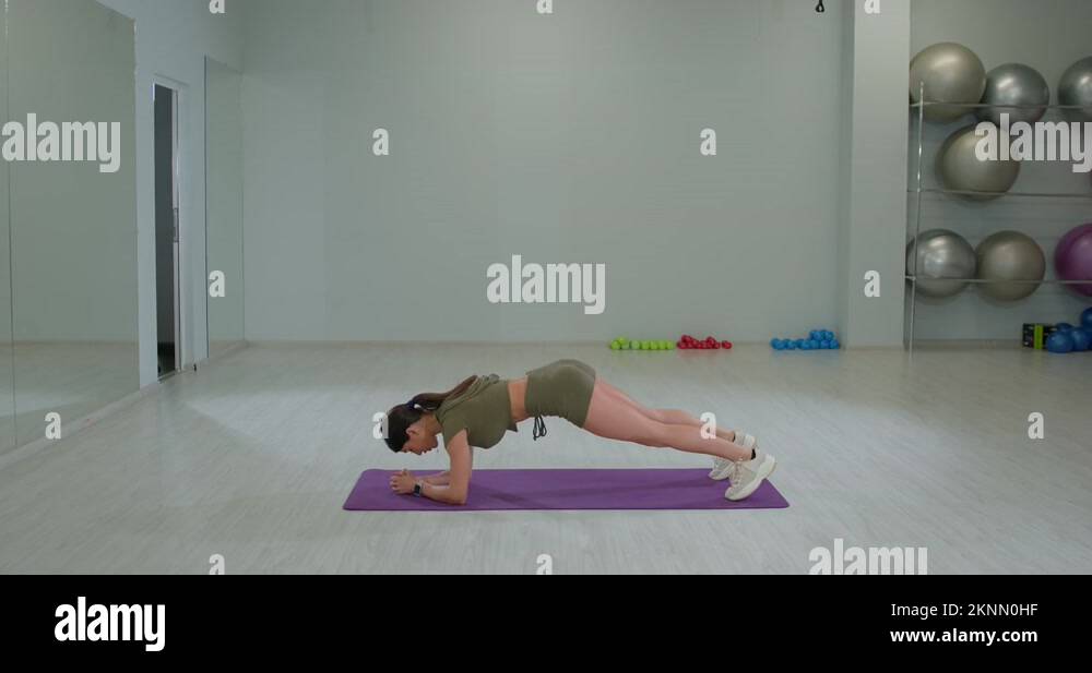 Athletic brunette girl performs a static plank exercise lying Stock ...