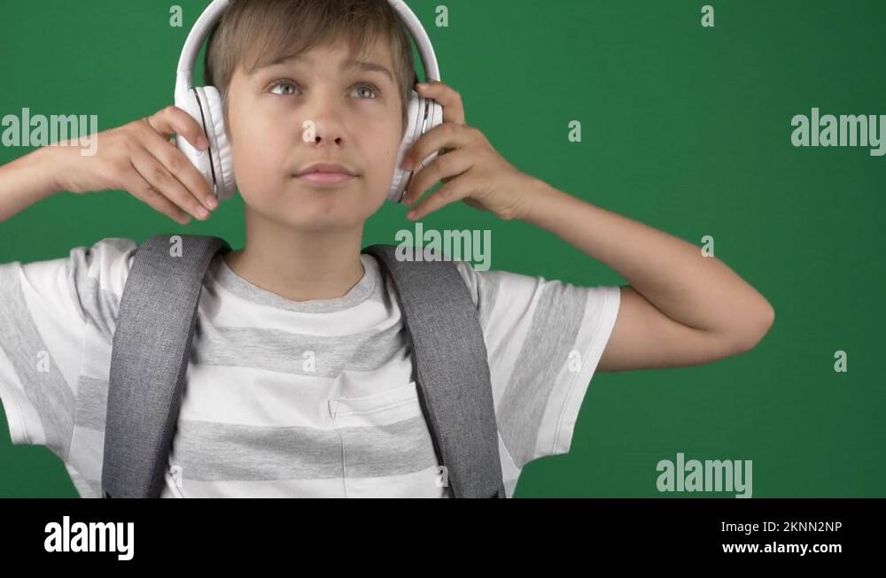 Handsome teenager with backpack standing against green screen chroma ...