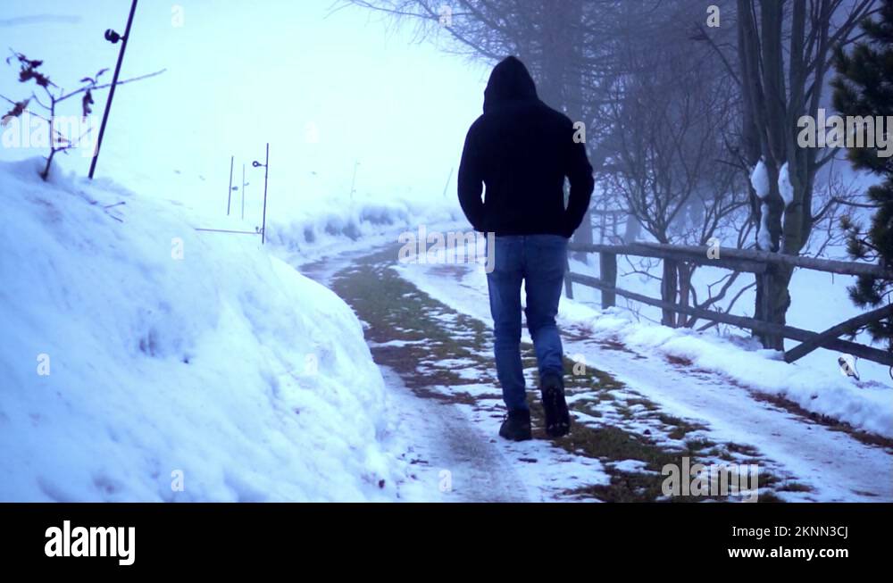 Depressed man walks along an old snowy path in the fog in winter Stock Video Footage - Alamy