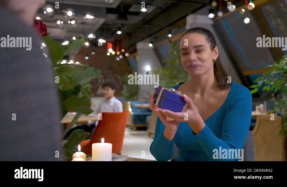 Excited young girl millennial is getting gift from boyfriend feeling ...