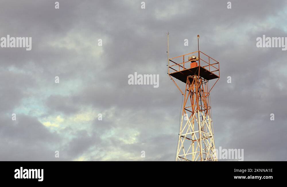 A rotating beacon light, mounted on a tower at a small airport, is ...