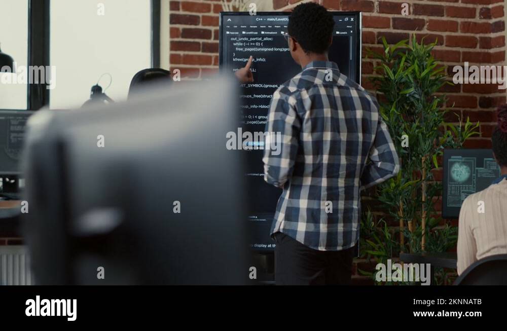 Team Of Coders Analyzing Code On Wall Screen Tv Comparing Errors Using Digital Stock Video