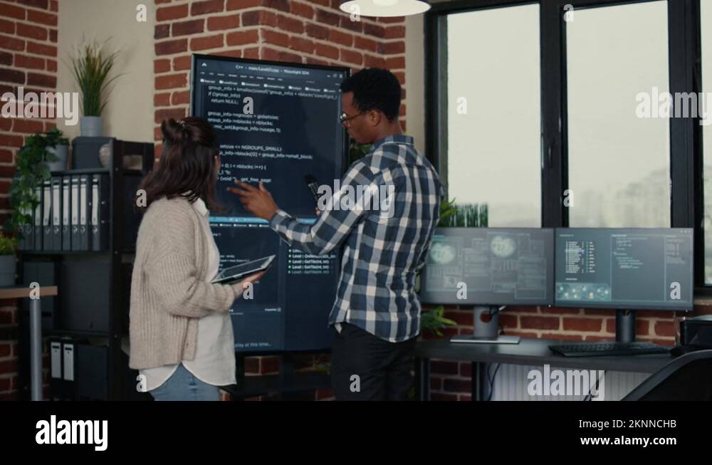 Software Developers Analyzing Source Code On Wall Screen Tv Comparing Errors Stock Video Footage
