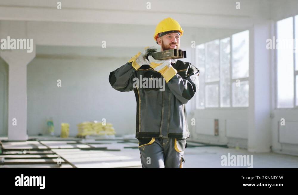 At construction site charismatic construction worker man carrying the ...