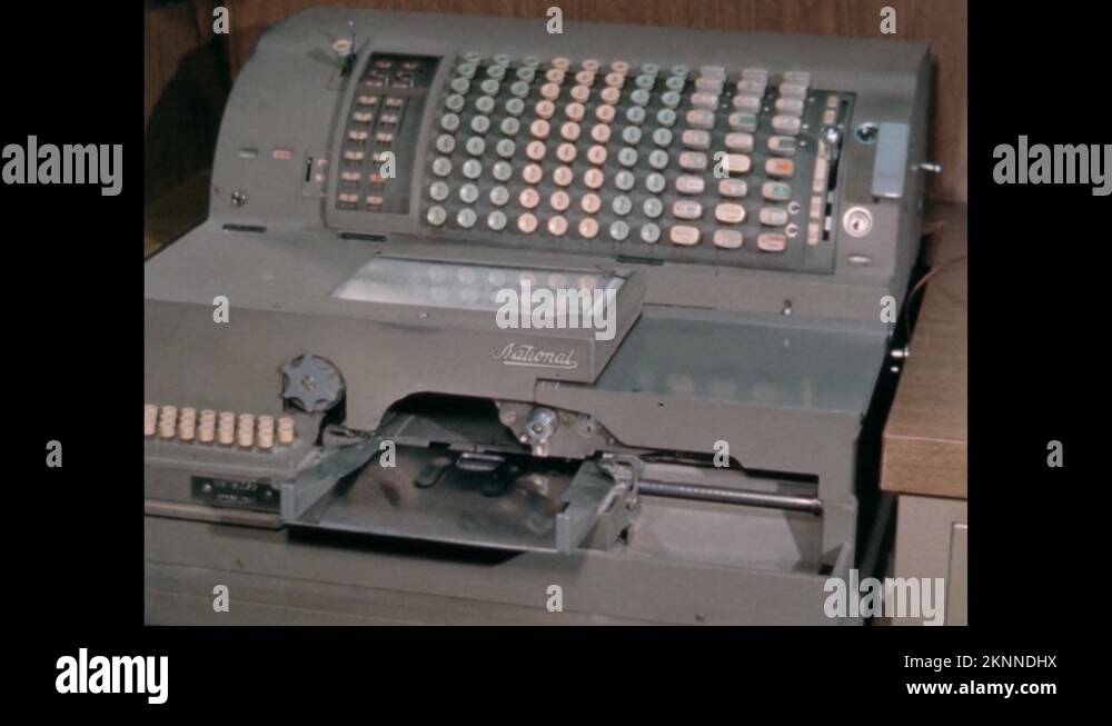 1960s: Woman uses bank machine. Men in bank. Men stand, shake hands ...