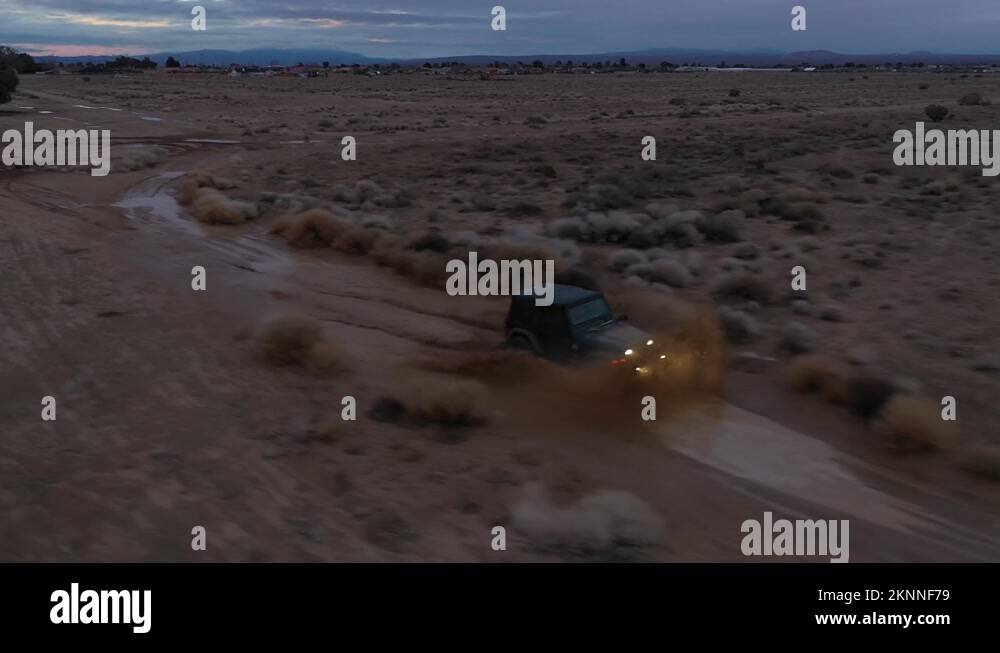 A jeep driving on off-road trails in the Mojave Desert through puddles ...