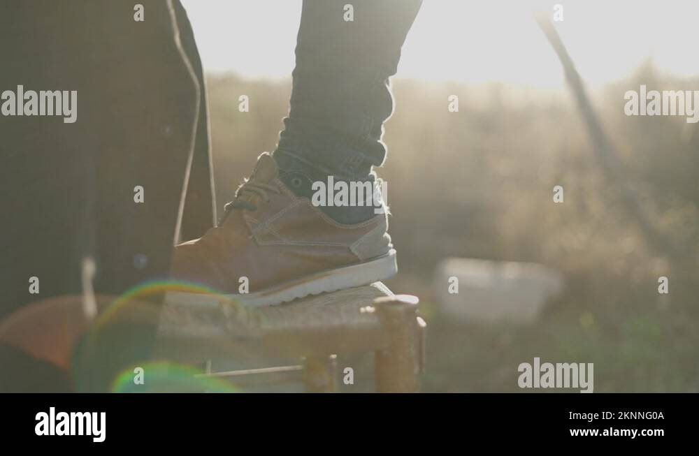 Backlit Guitarist's foot beating time on a chair while he is playing ...