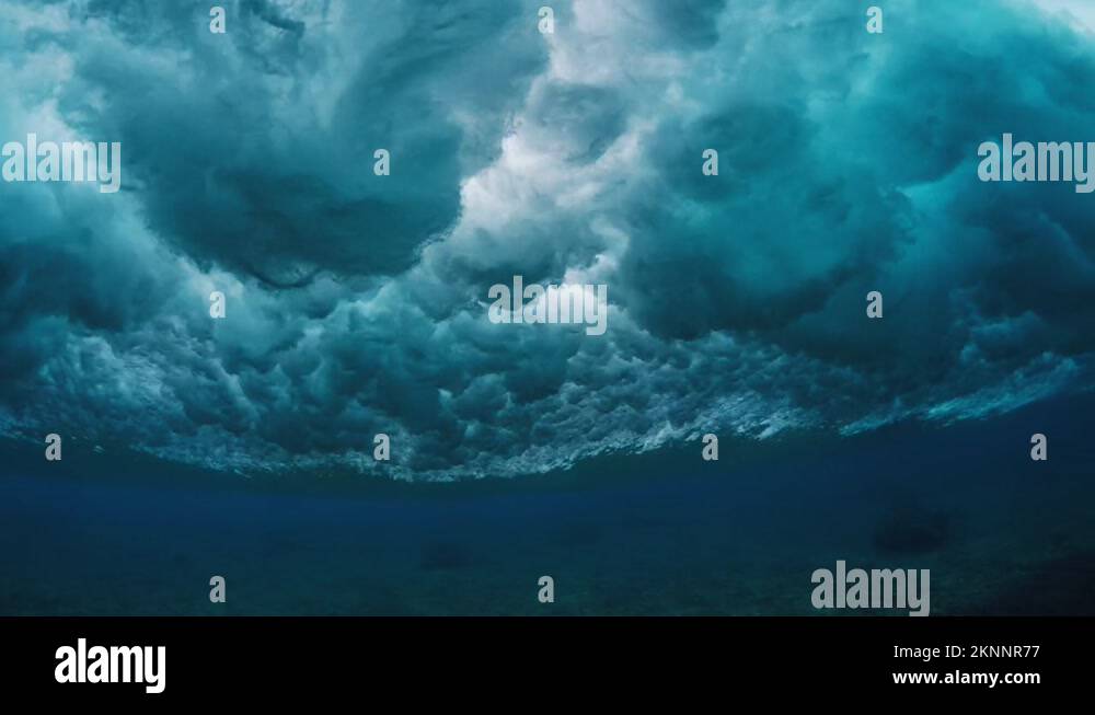 Ocean wave breaks at Sultans surf spot in Maldives. Underwater view of ...
