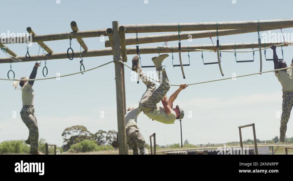 Fit diverse group of soldiers using hanging rope and rings on army ...