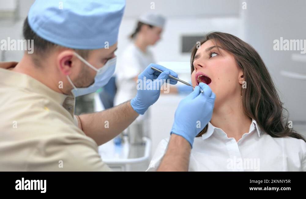 Male dentist practitioner examining teeth of female patient use ...