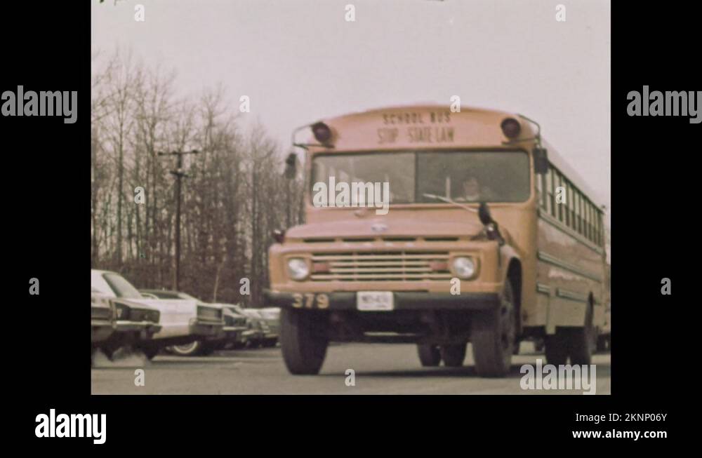 1960s: School. Children run to school bus. Buses drive down road. Man ...