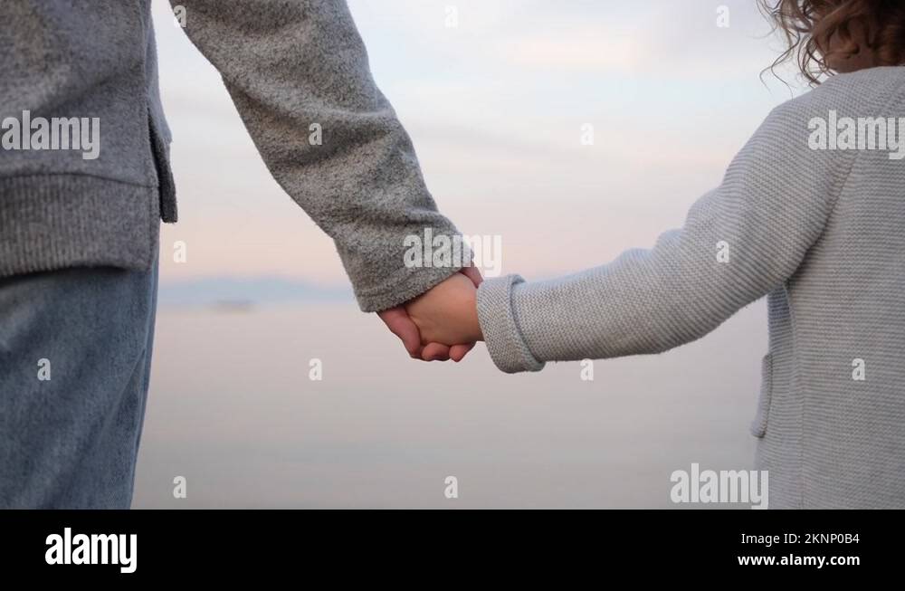 Close up view of the hand of a little girl shaking hands with her older ...