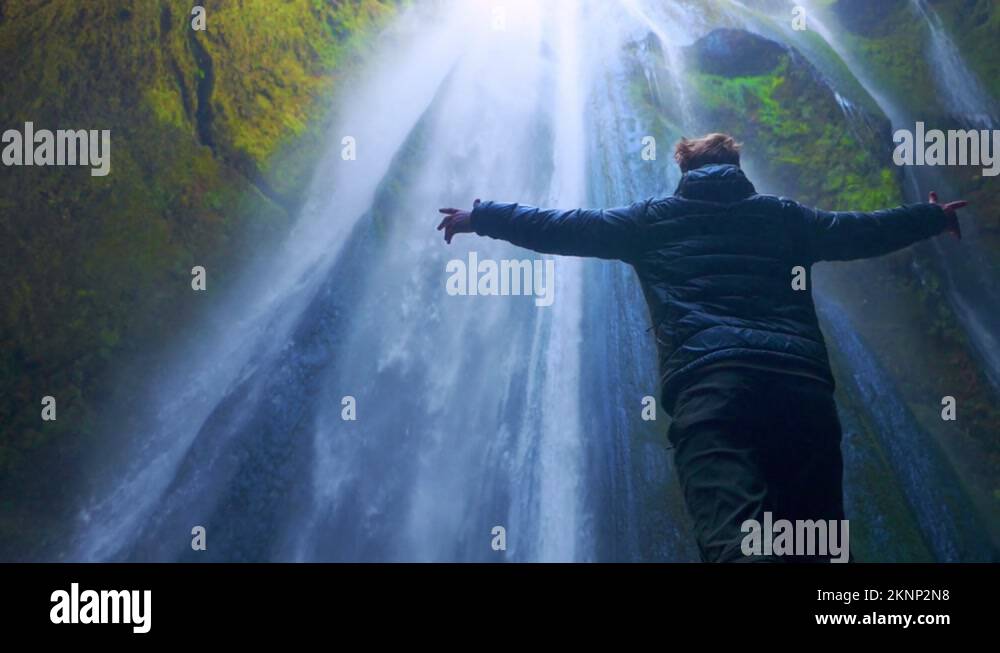 Man Standing Inside The Cave Covered With Moss At Gljufrabui Waterfall ...