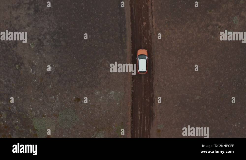 Aerial birds eye overhead top down view of car driving on dirt roads ...