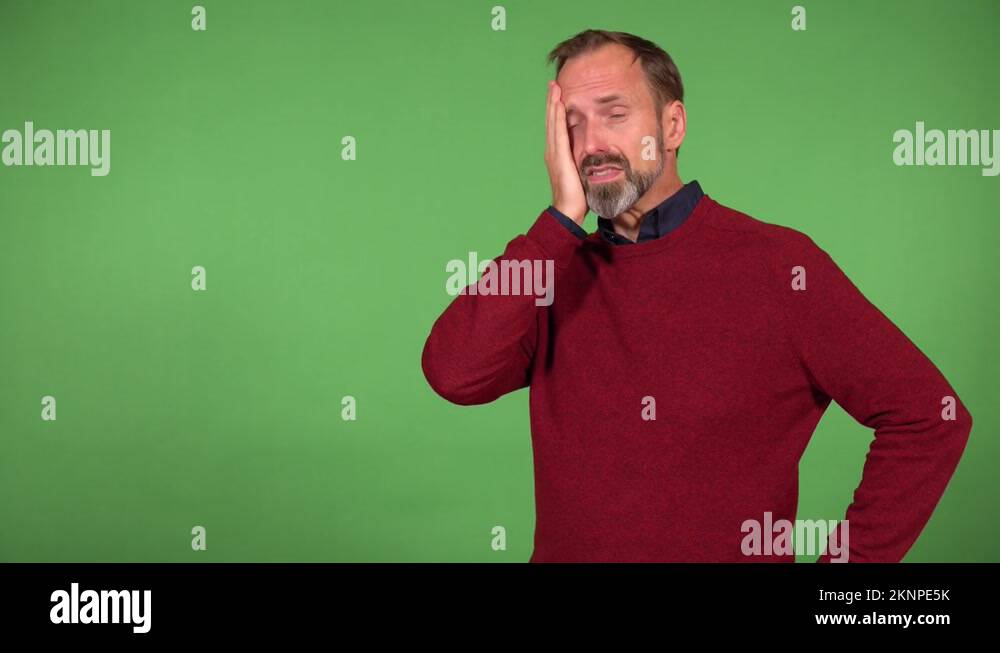 A middle-aged handsome Caucasian man has a headache - green screen ...
