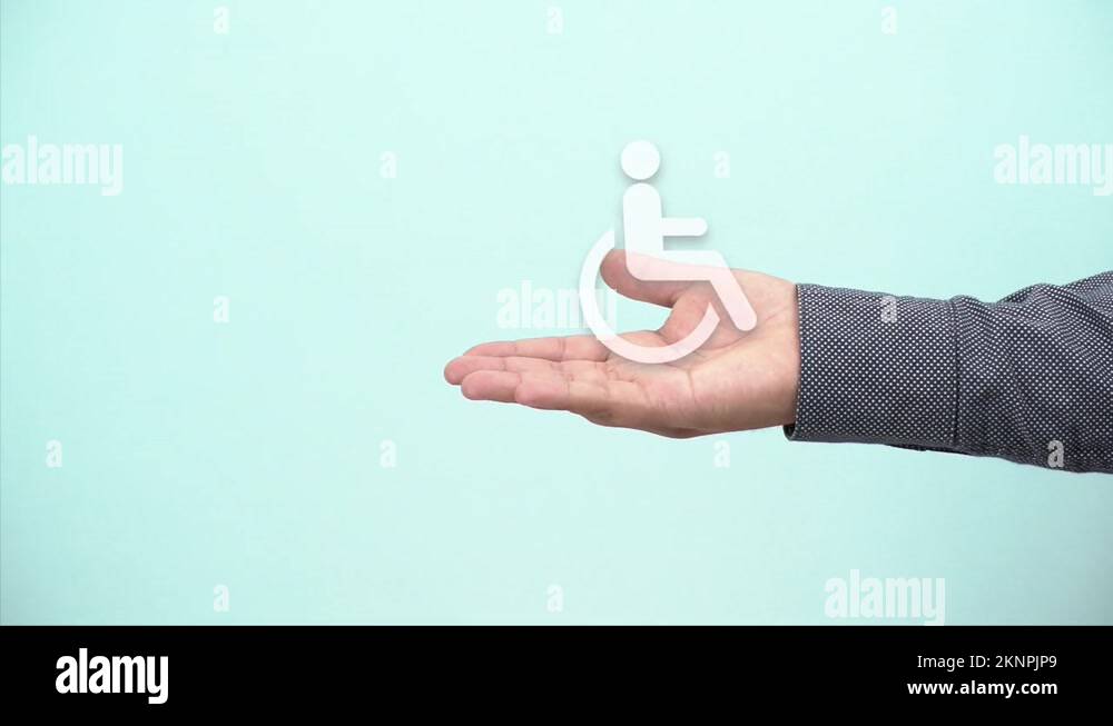 concept of disability. hand shows symbol of person in wheelchair on ...