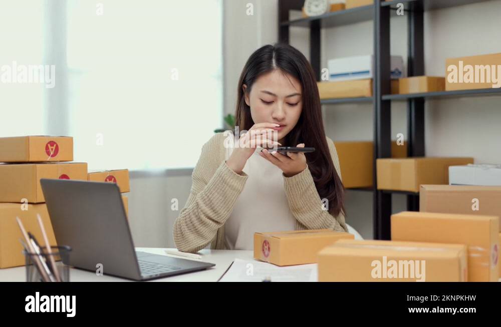 Young asian business woman writing address to sending product to ...