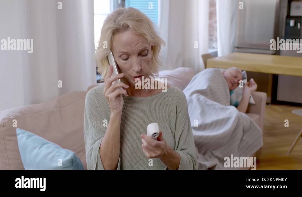Mature woman talking on phone with doctor about sick husband. Realtime ...