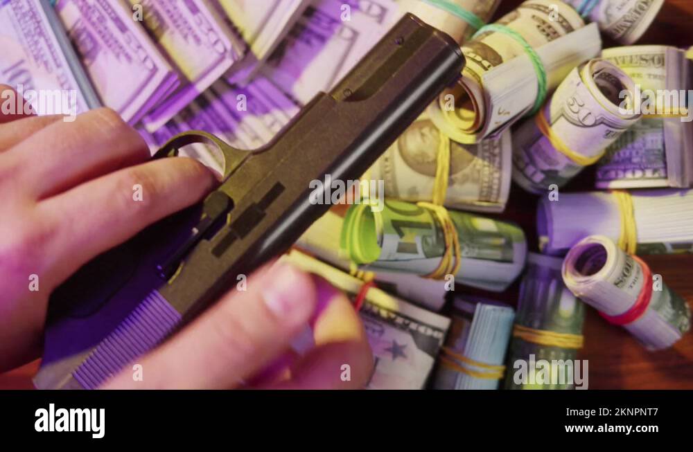 Putting pistol on money cash close-up. Euro and dollar banknotes with ...