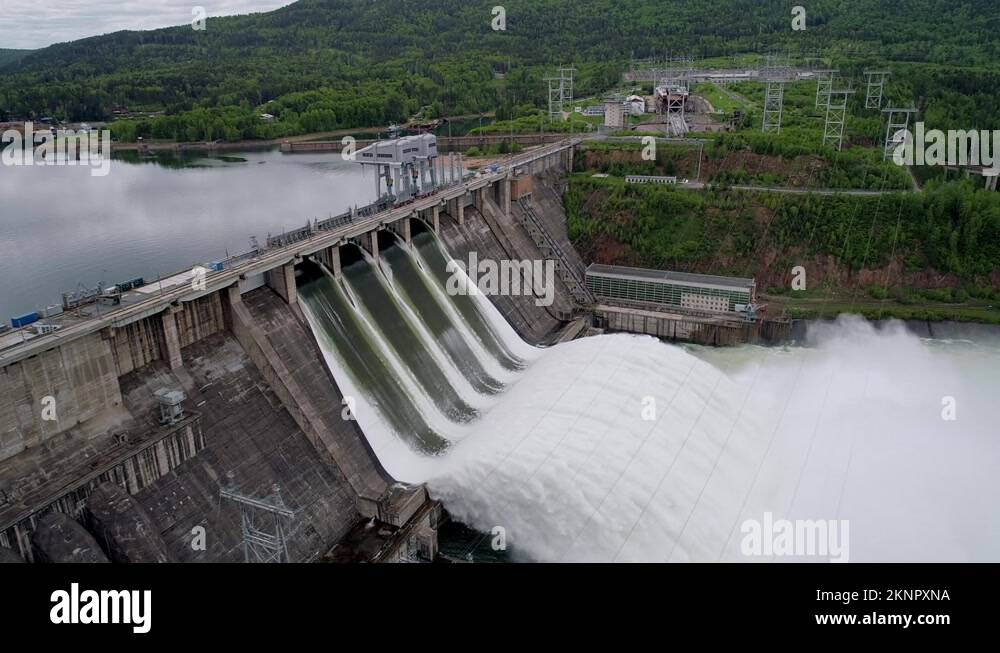 Aerial side view of water discharge at hydroelectric power plant of ...