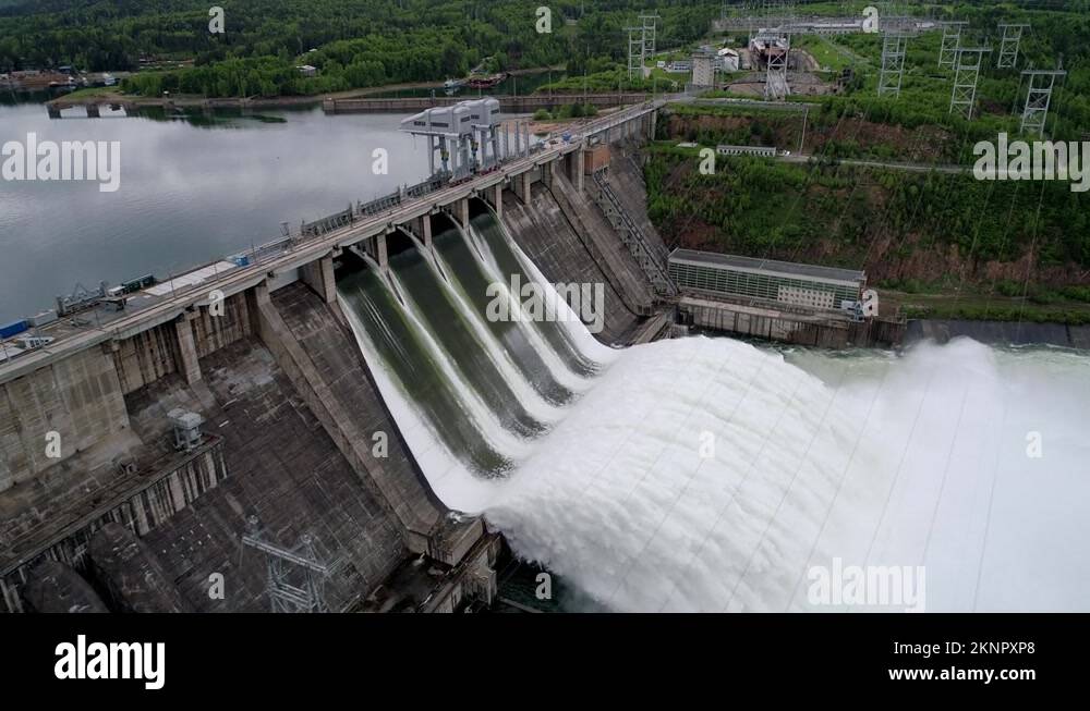 Aerial side view of water discharge at hydroelectric power plant of ...