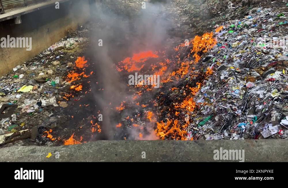 Fire burning trash heap, pouring water to extinguish - environment ...