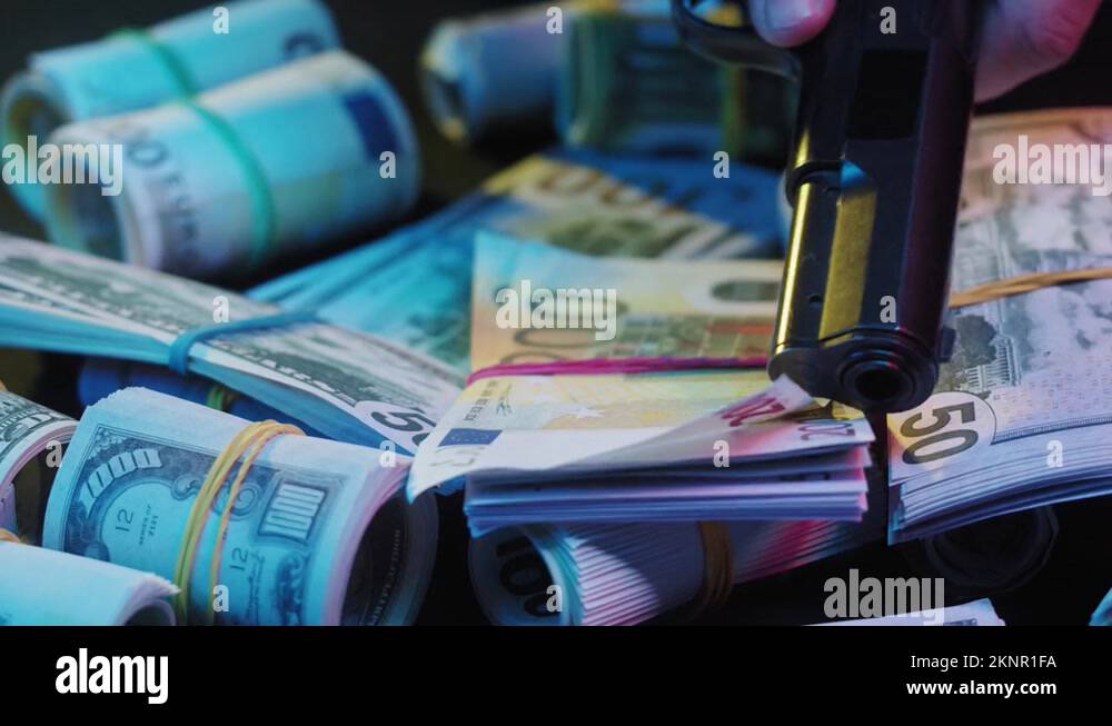 Putting pistol on money cash close-up. Euro and dollar banknotes with ...