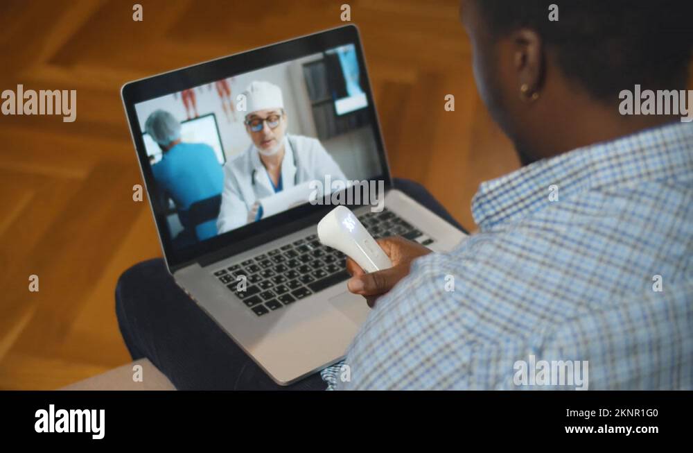 Back view of man measuring temperature making video call with doctor ...