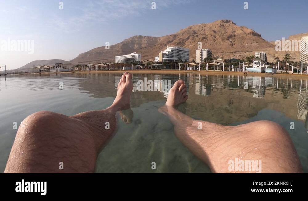 Floating in Dead Sea POV, hotels beach and mountains in Ein Bokek, Israel Stock Video Footage ...