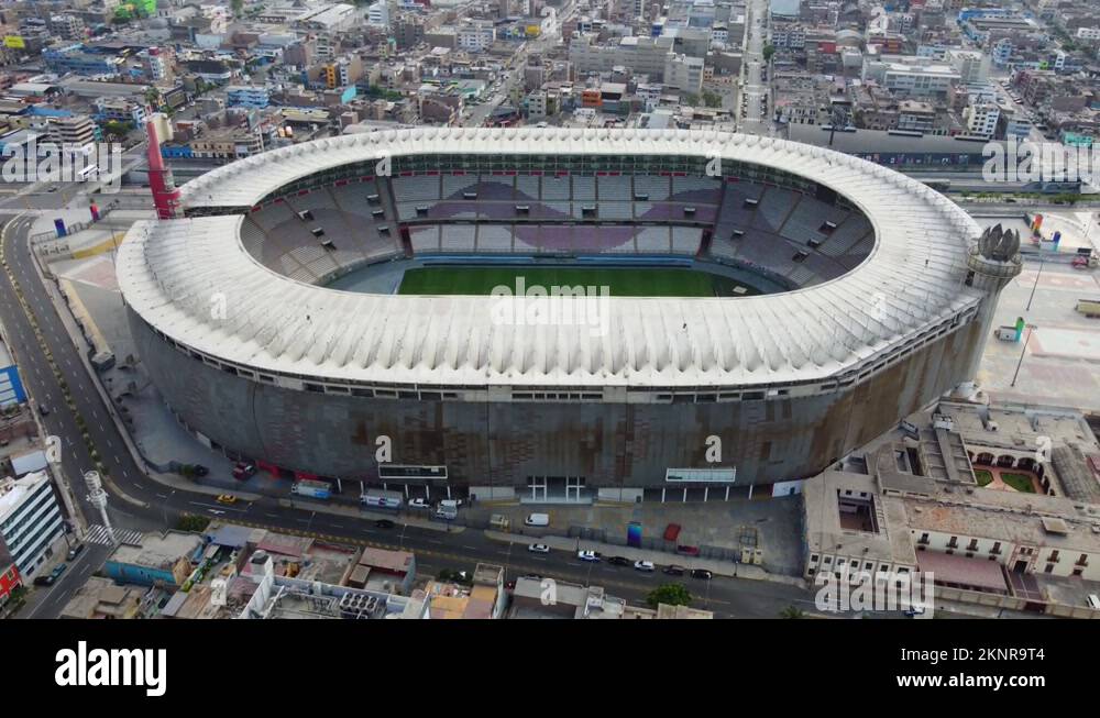 Drone footage of Peru's national soccer stadium, flying forwards, tilt ...