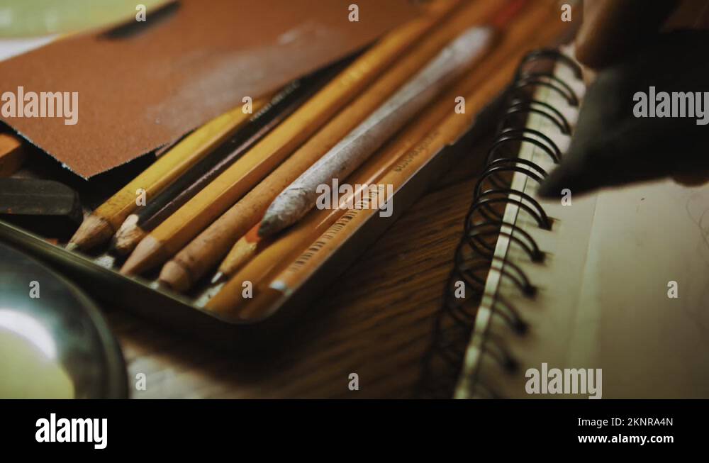 Fixing drawing with kneaded eraser or rubber, sketchbook, hand and pile ...