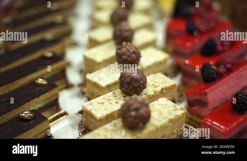 Delicious sweet pastry, cakes and cookies in a row on a showcase in ...