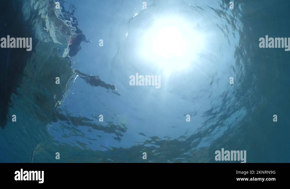 diver jumping from boat underwater diving slow ocean sun beams and rays ...